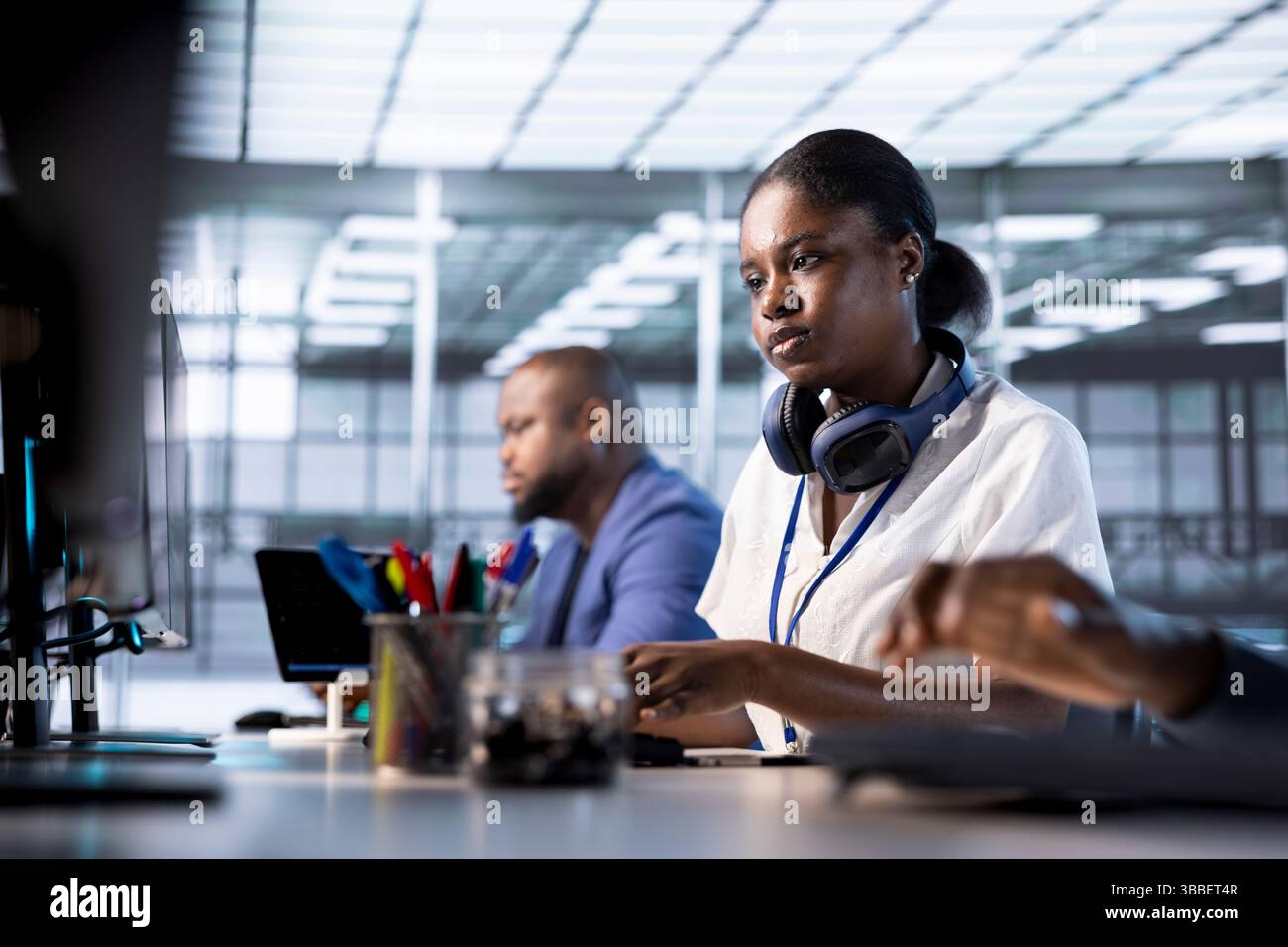 African american engineer next to coworkers in server farm checking ...