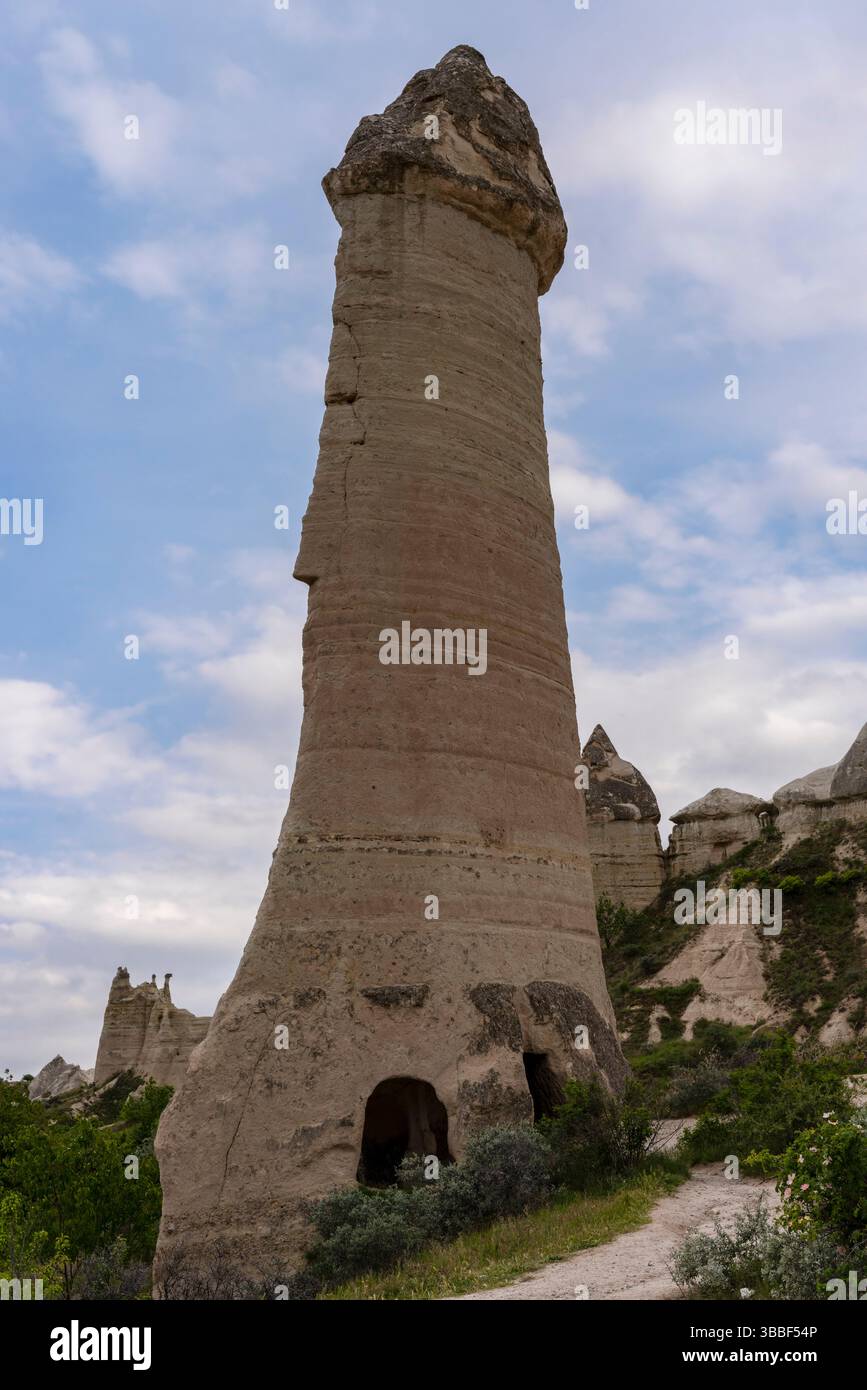A single, towering fairy chimney with a flat top rises above the valley ...
