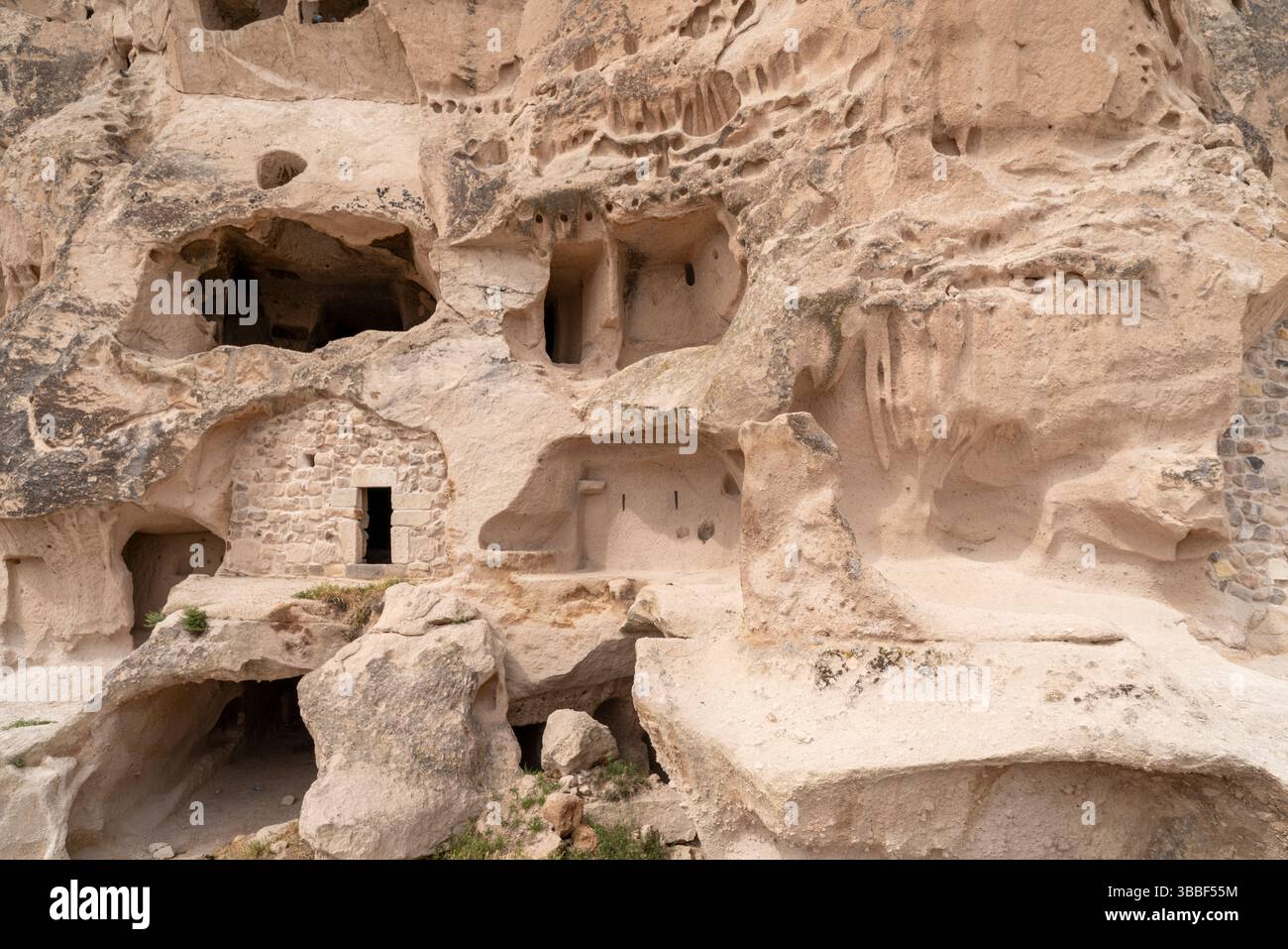 Multiple levels of caves and windows are carved into the vertical rock ...