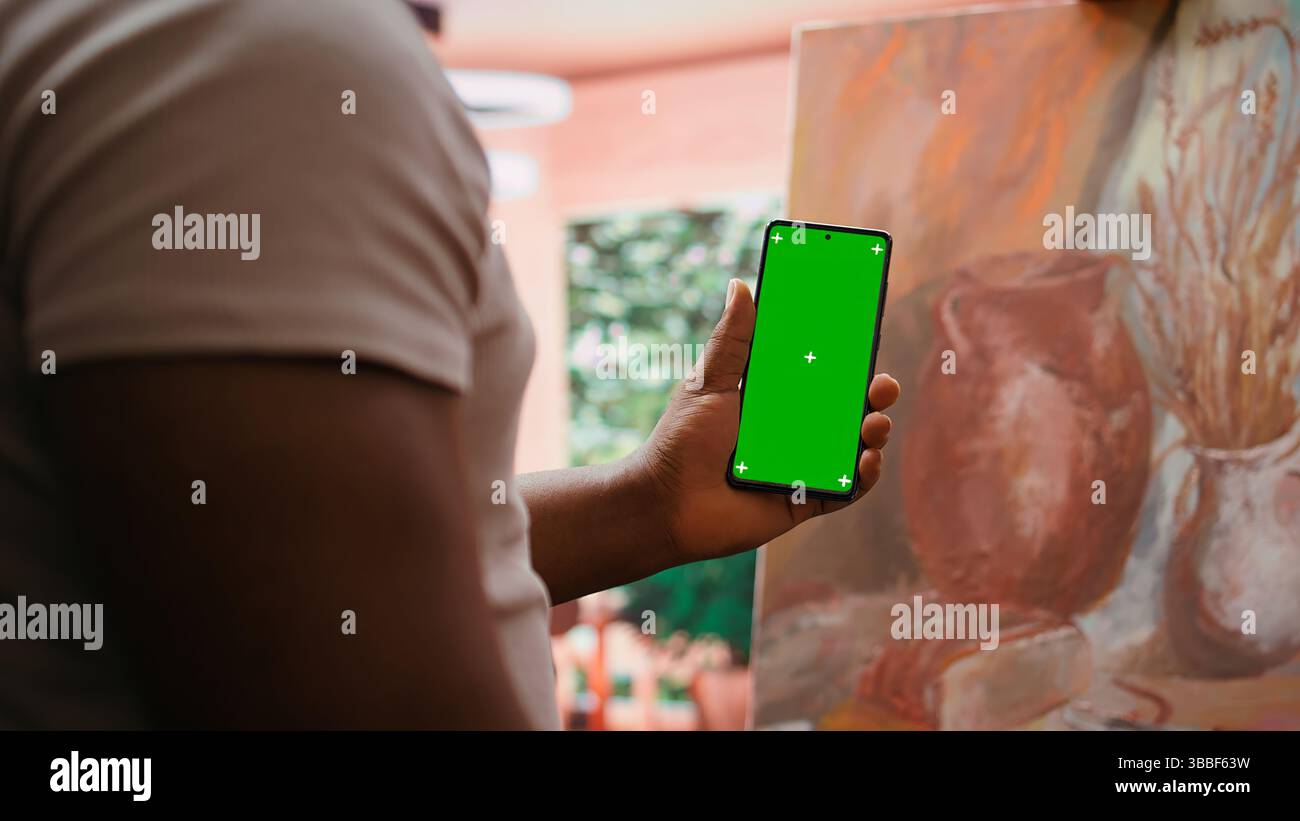 African american artist holding device with green screen mockup in art ...