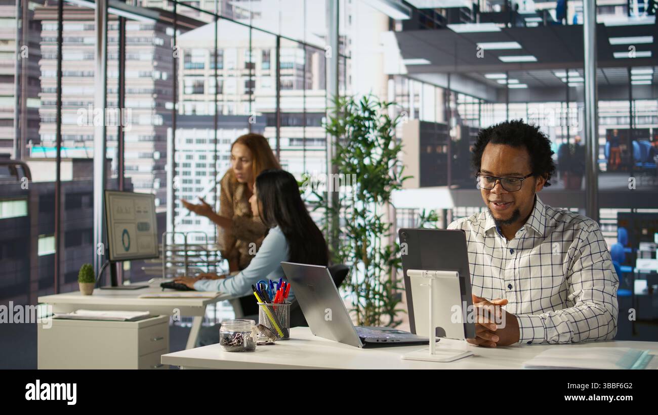 Black man employee joins telecommuting session at office desk ...