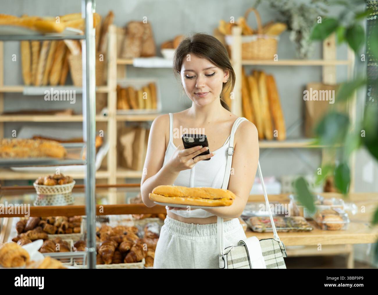 Female customer scanning QR code on label of fresh baked goods in ...