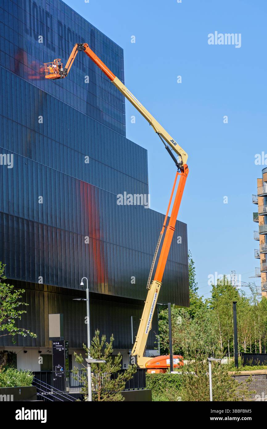 Workers on a Cherry picker (aerial platform) working on the electronic ...