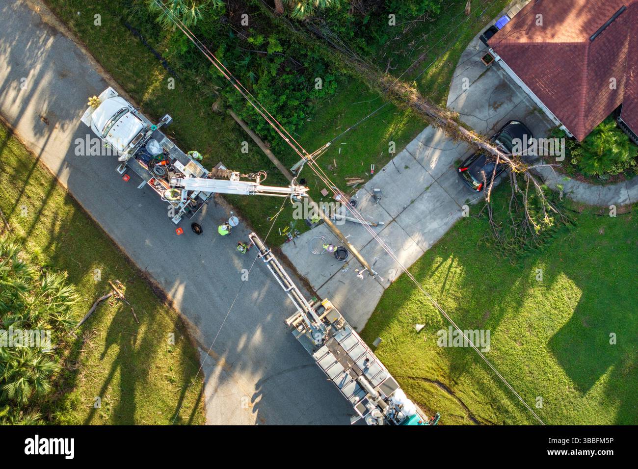 Hurricane aftermath in Florida. Workers using bucket trucks to repair blown down electrical ...