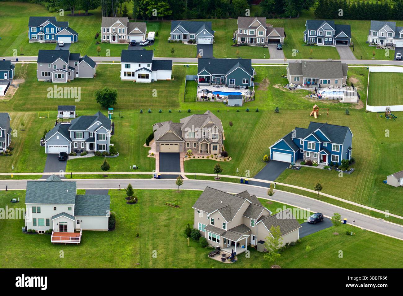 Upscale suburban homes with large backyards and green grassy lawns in ...