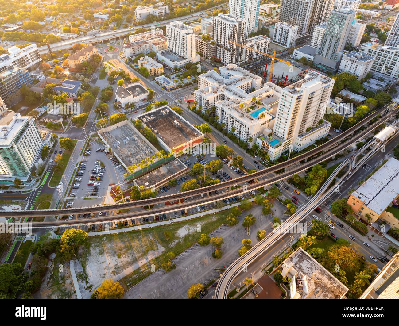 View from above of public train passing through downtown railroad of Miami, Florida, USA ...
