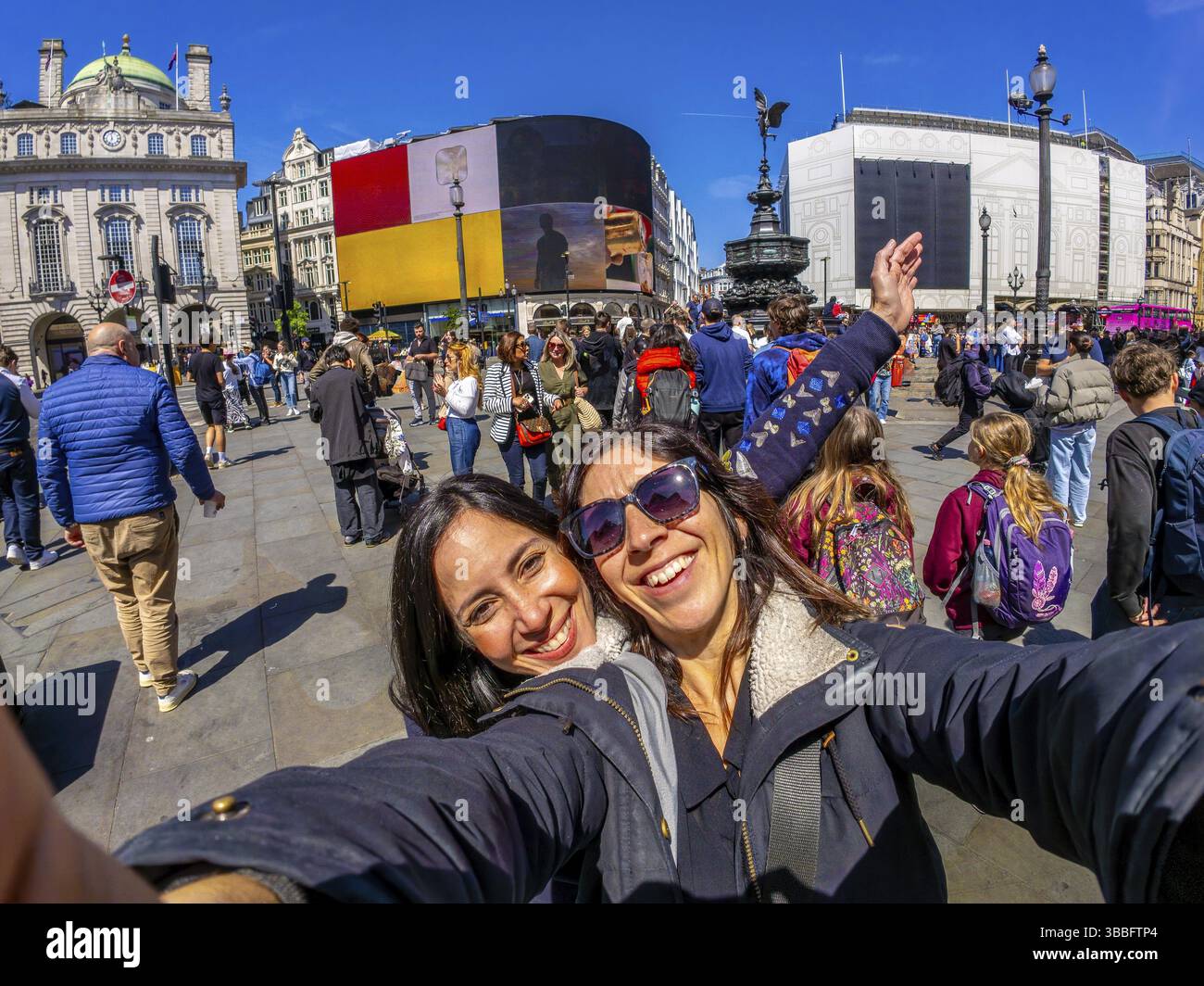 Two happy tourists taking a selfie with fisheye lens in piccadilly ...