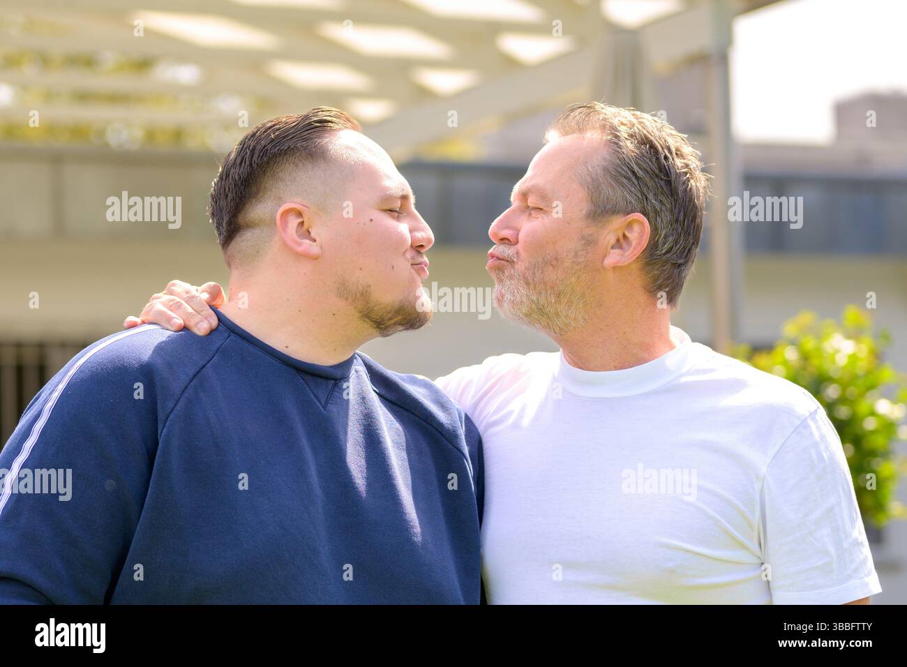 A cheerful and playful moment between father and son as they lean in ...