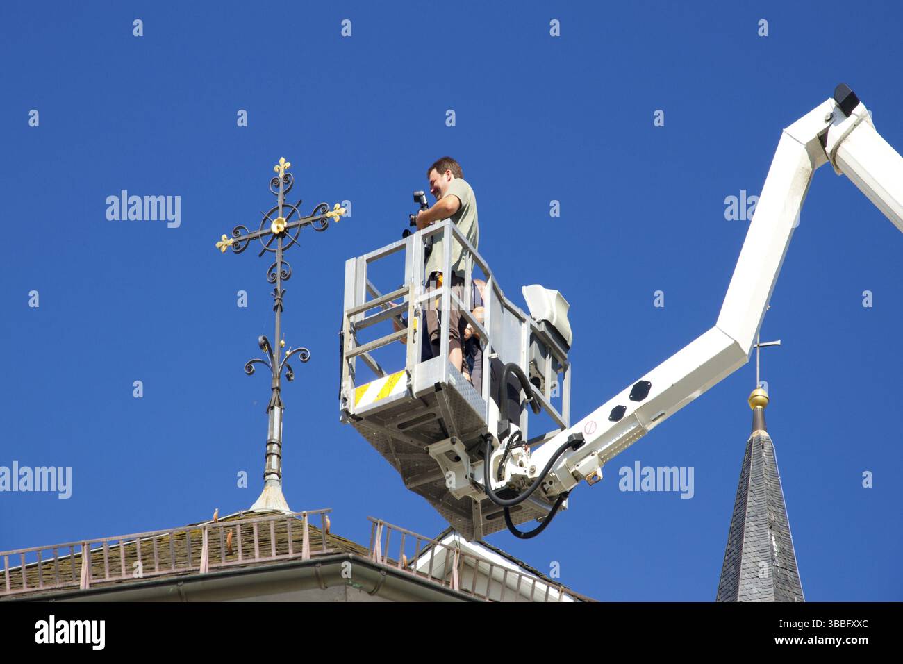 The roof of a church with a cross is being renovated, lift truck, lift ...