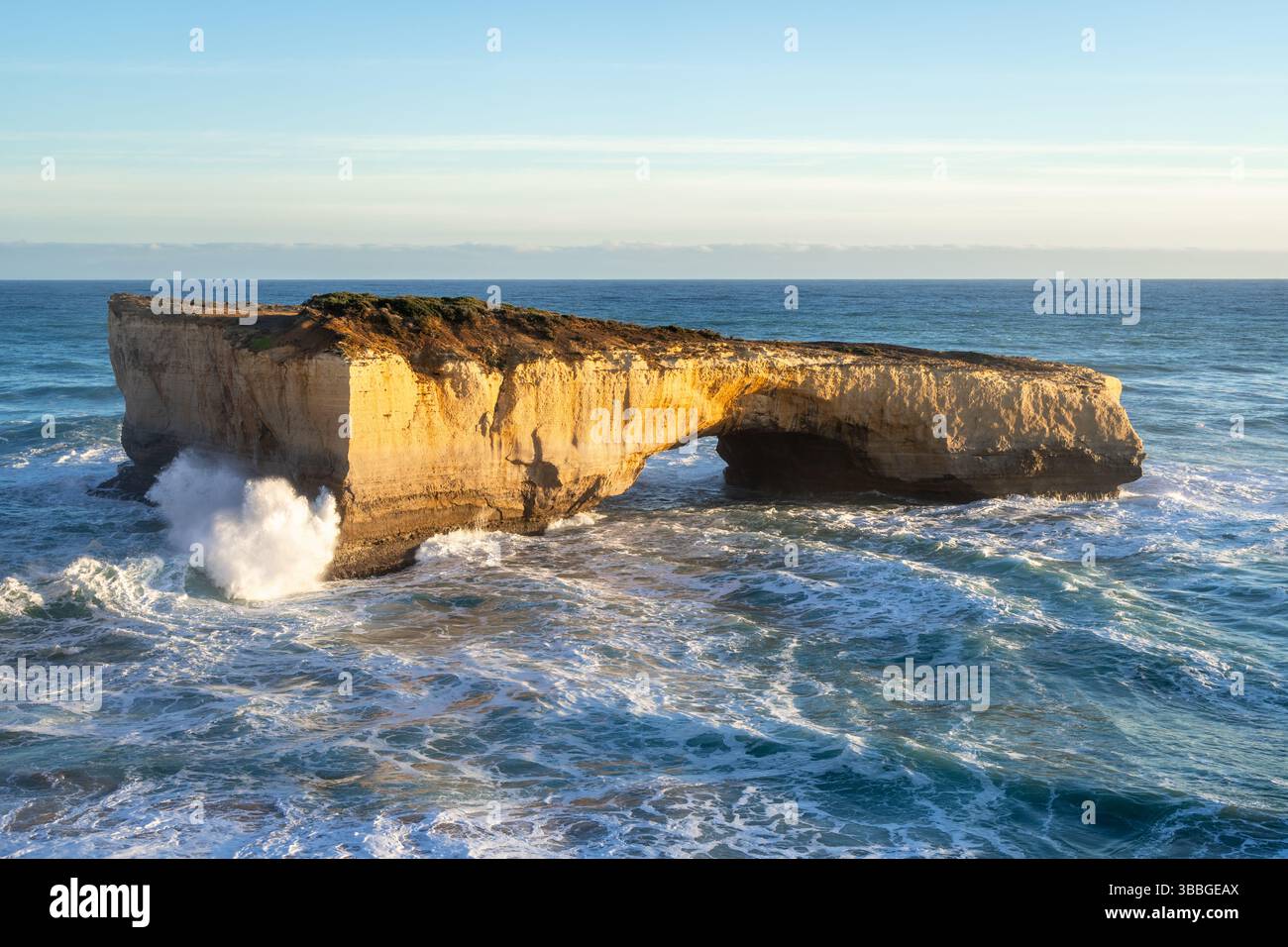 Golden light illuminates London Bridge, a famous rock formation at the ...