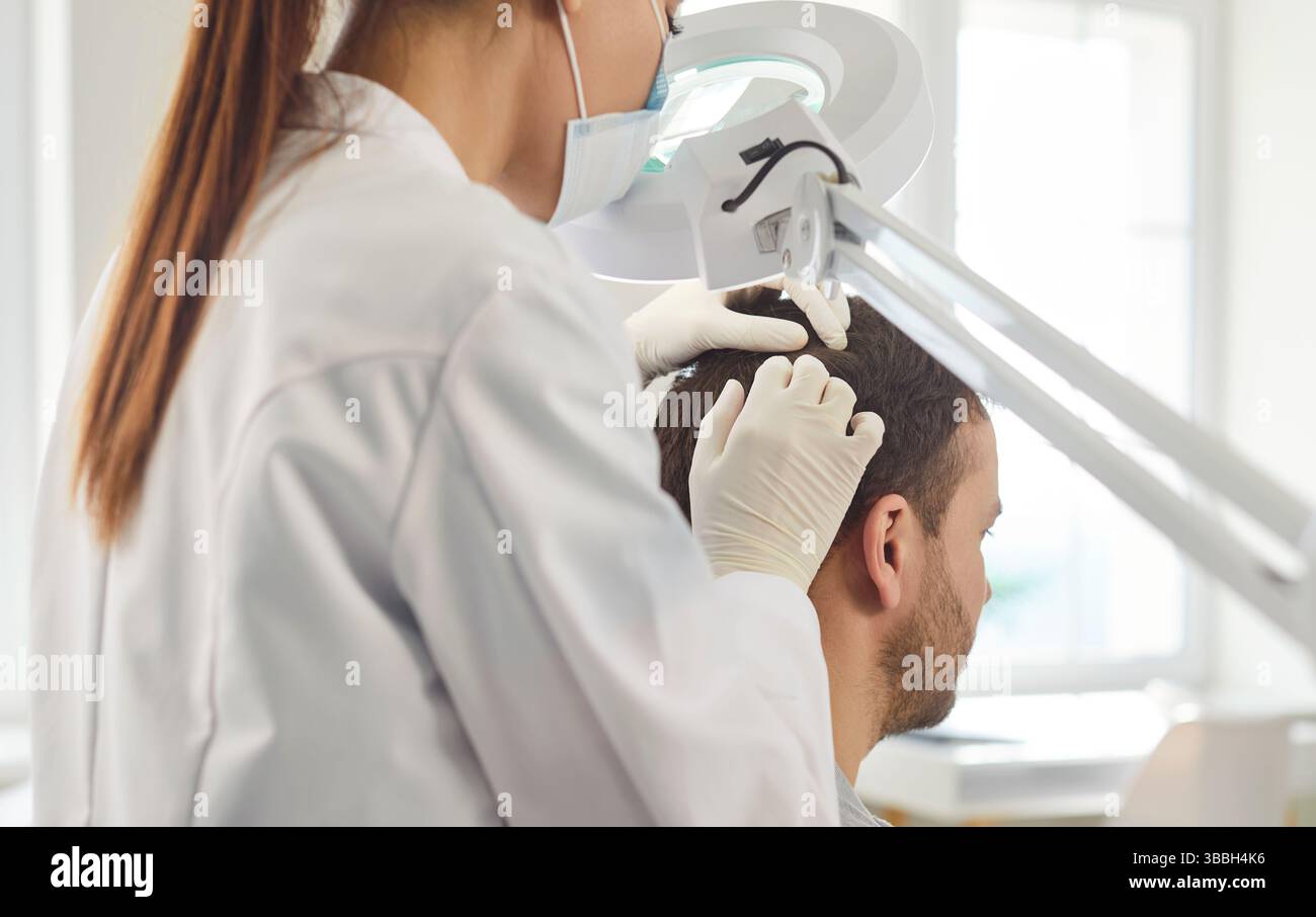 Dermatologist examines scalp of male patient with dandruff and hair ...