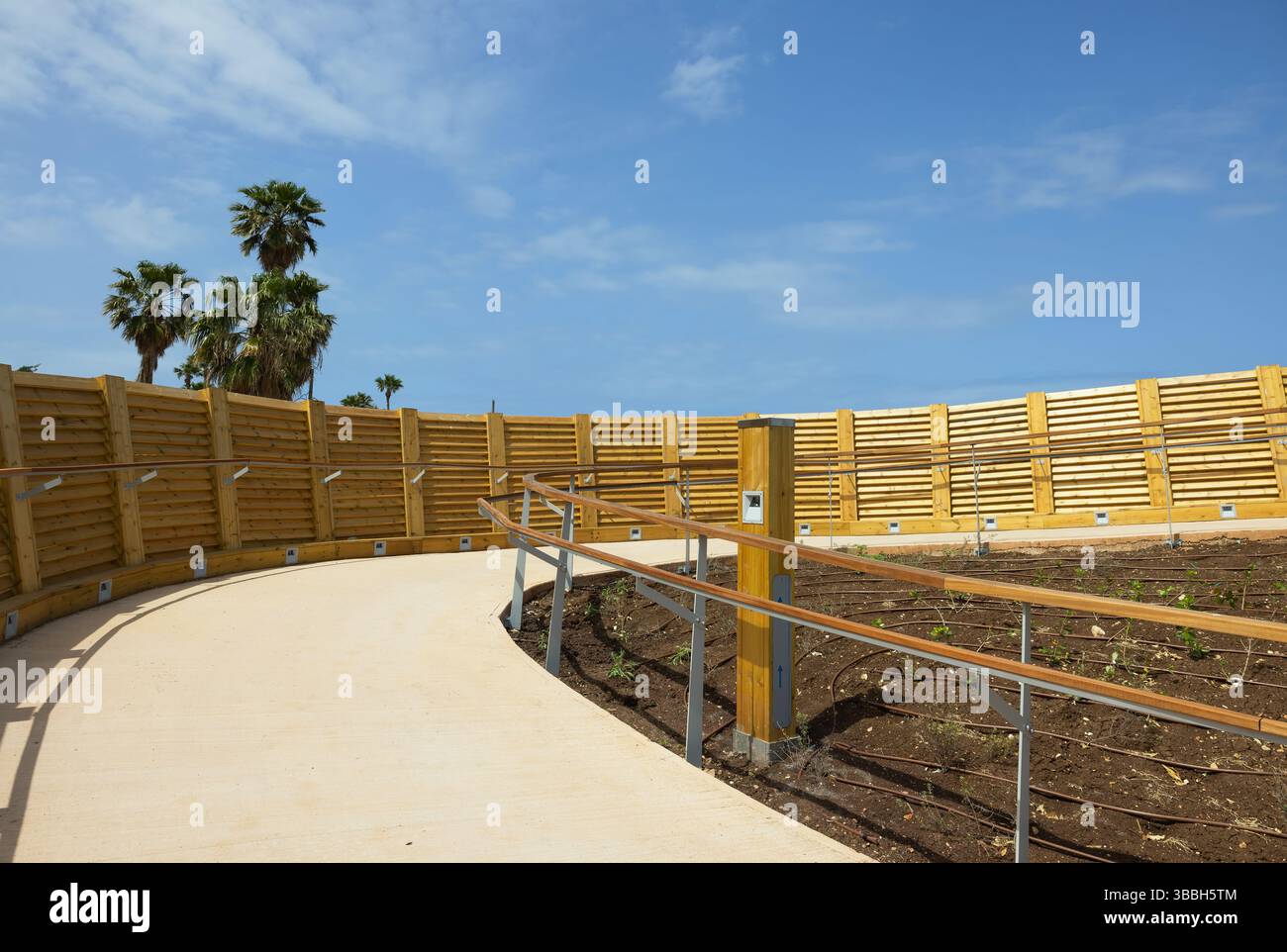 section of pedestrian path with wooden fence against the background of ...