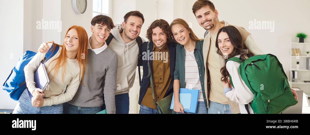 Group portrait of happy smiling students standing in classroom, hugging ...