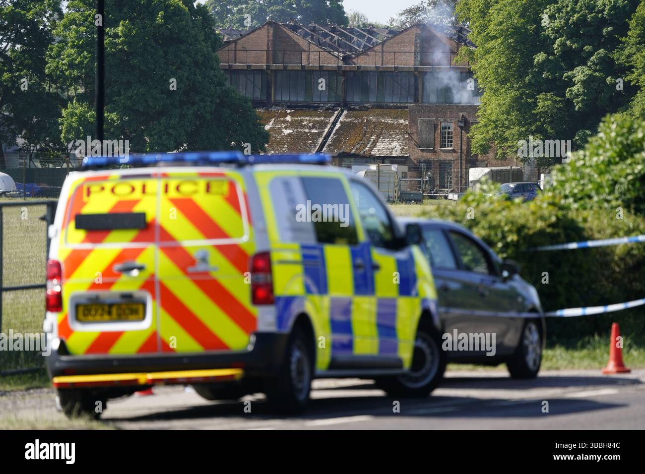 Police officers patrol at a cordon near the scene of a fire where two ...