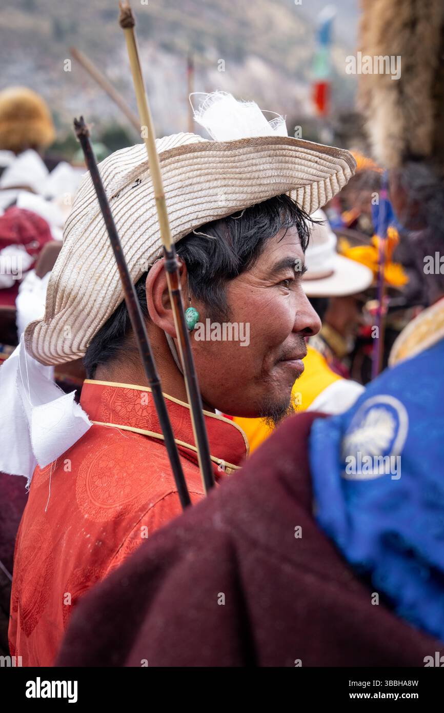 Portrait of a Nubri man in traditional dress with arrows over his ...