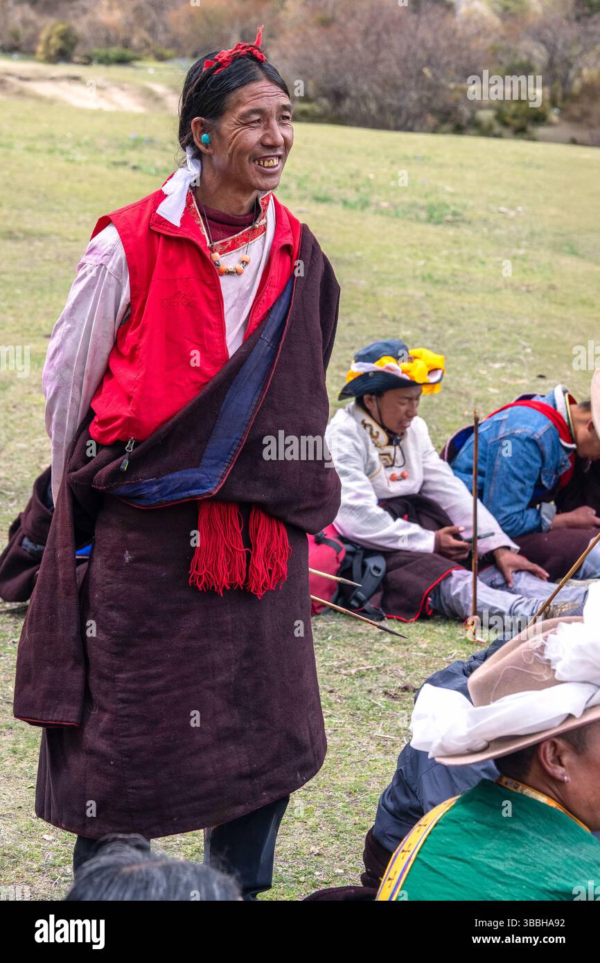 A smiling Nubri man dressed in traditional attire participates in the ...
