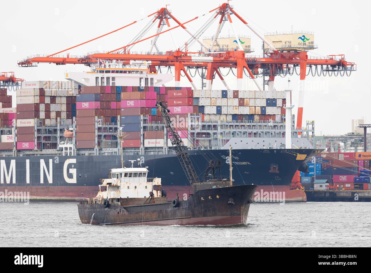 A ship drives a loaded container ship inside Tokyo Bay. Japan is ...