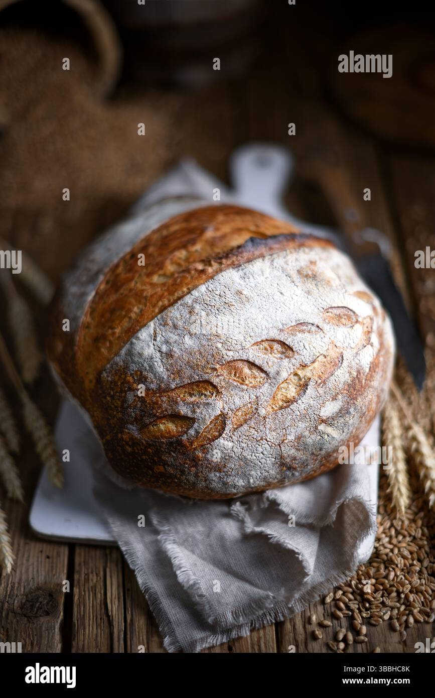 Browned crusty sourdough bread with cracked top and firm crust set on ...