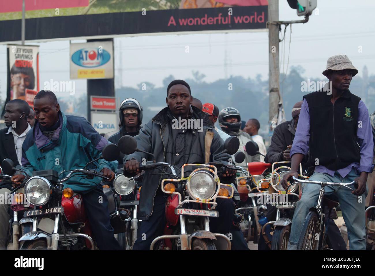 Kampala, Uganda - August 25, 2010: Men on motorbikes and bikes are ...