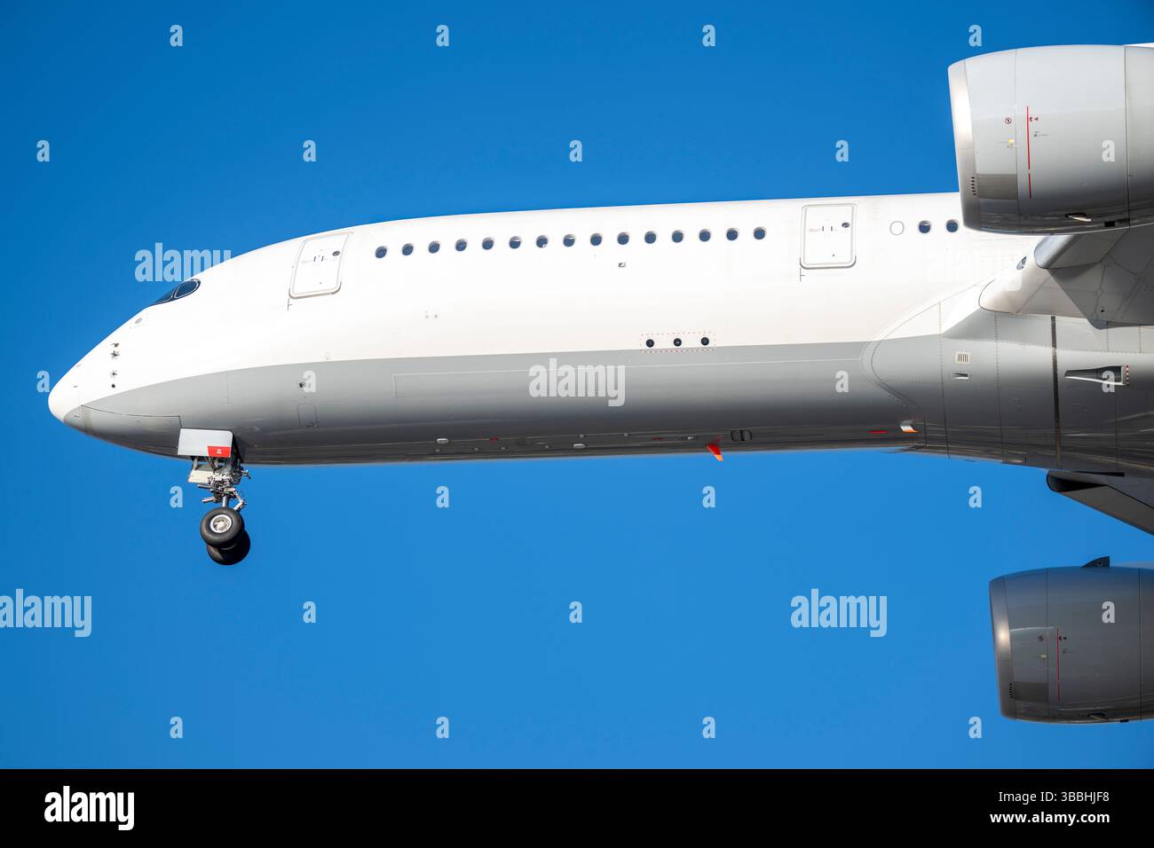 Fuselage detail Airbus A350-900 white flying overhead clear blue sky ...