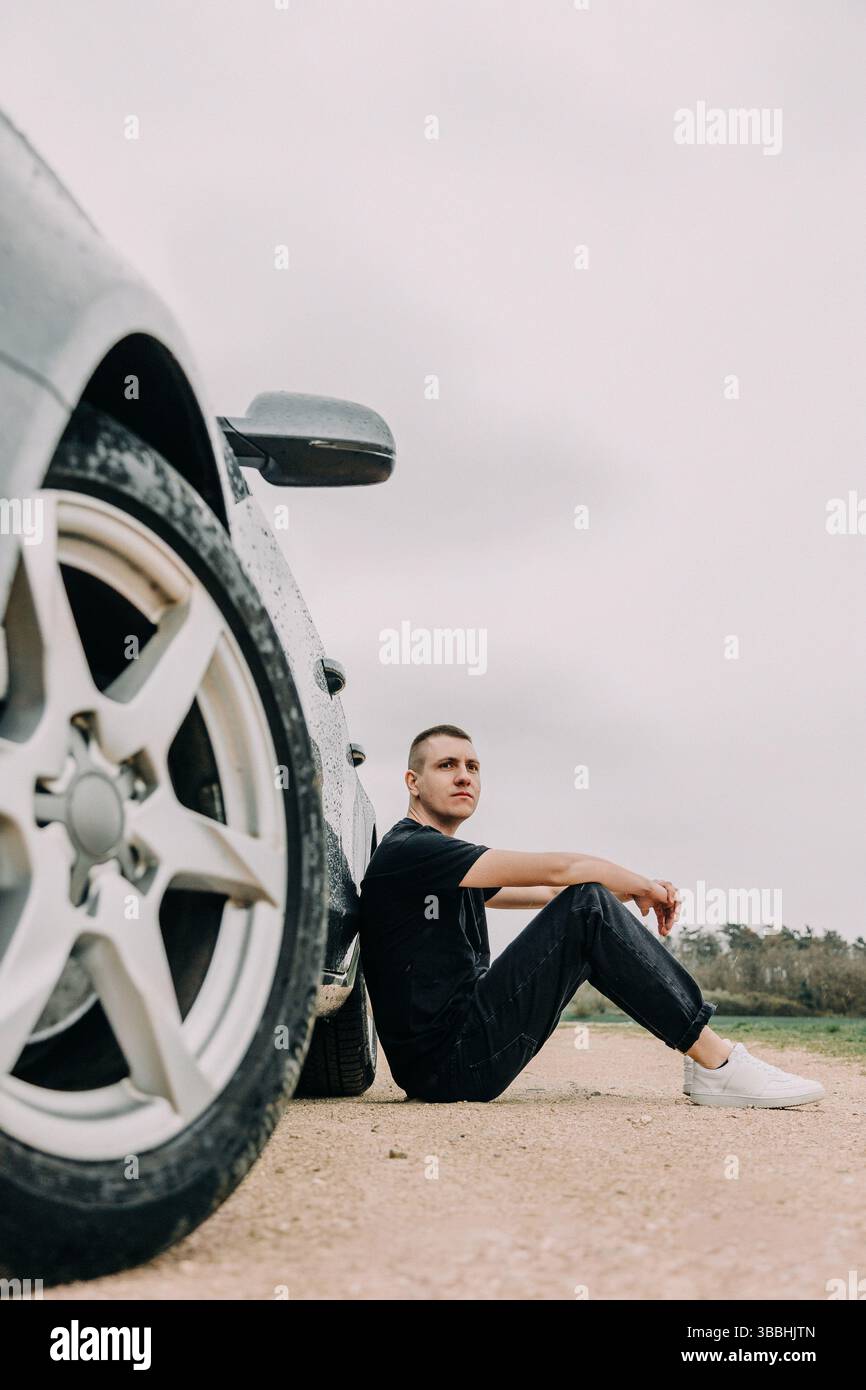 Man sitting beside road hi-res stock photography and images - Alamy