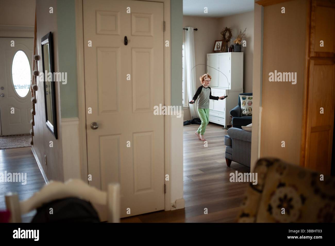 Redheaded Boy Jumping Rope Inside Cozy Home Living Room at Sunset Stock ...