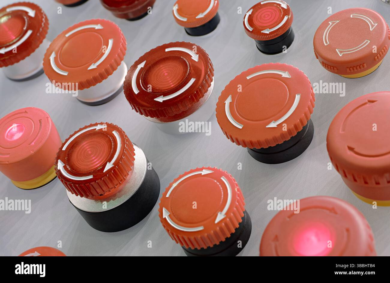 Multiple red emergency stop buttons on a grey metal panel, close up ...