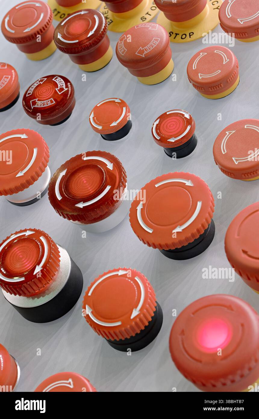 Multiple red emergency stop buttons on a grey metal panel, close up ...