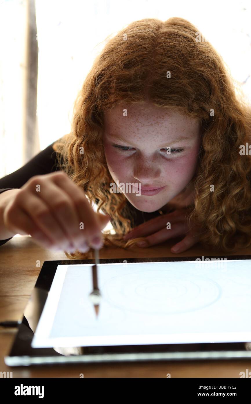 Girl drawing circles with pair of compasses and pencil maths skills ...