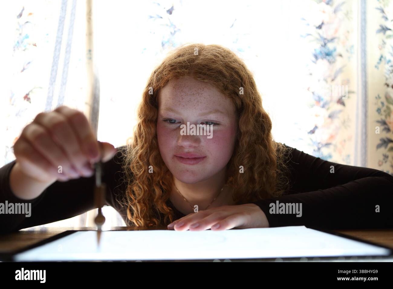 Girl drawing circles with pair of compasses and pencil maths skills ...