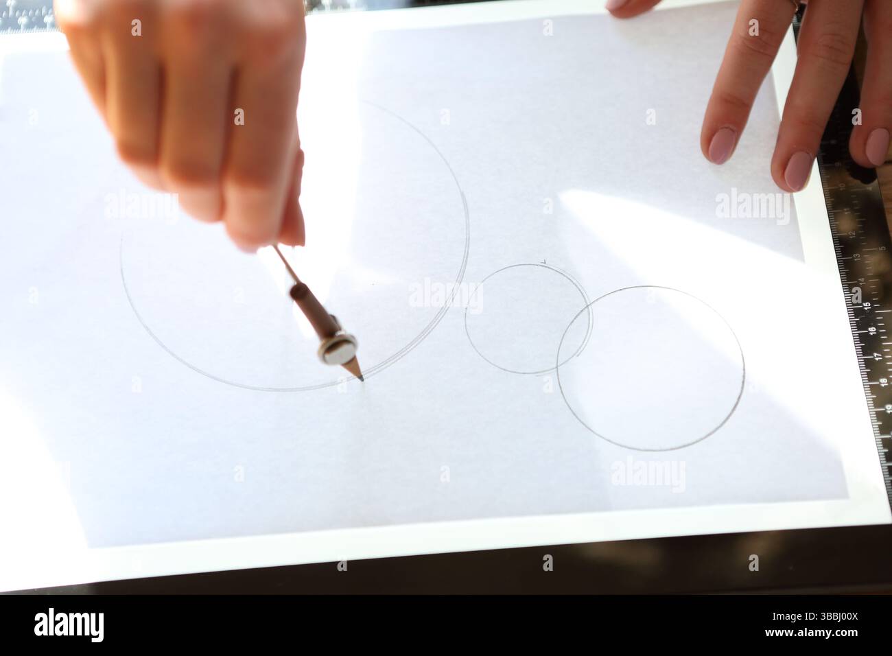 Girl drawing circles with pair of compasses and pencil maths skills ...