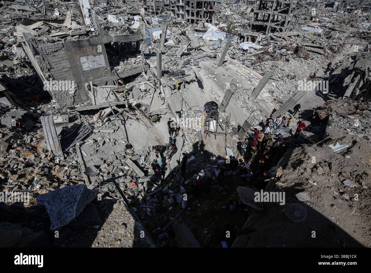 People sift through the rubble of the Zinati family home in Jabalia in ...