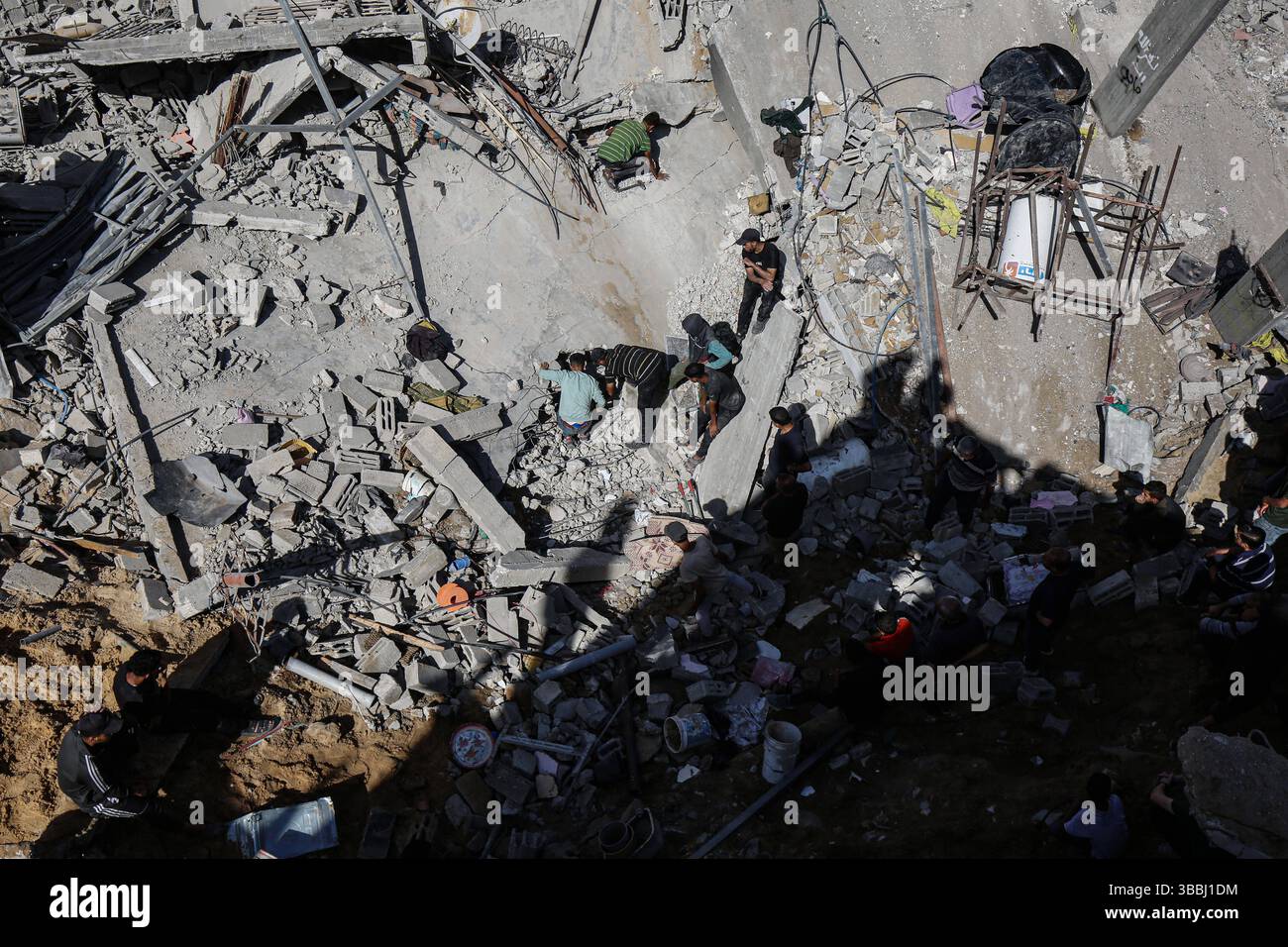 People sift through the rubble of the Zinati family home in Jabalia in ...