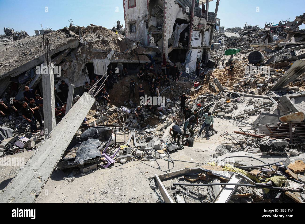 People sift through the rubble of the Zinati family home in Jabalia in ...