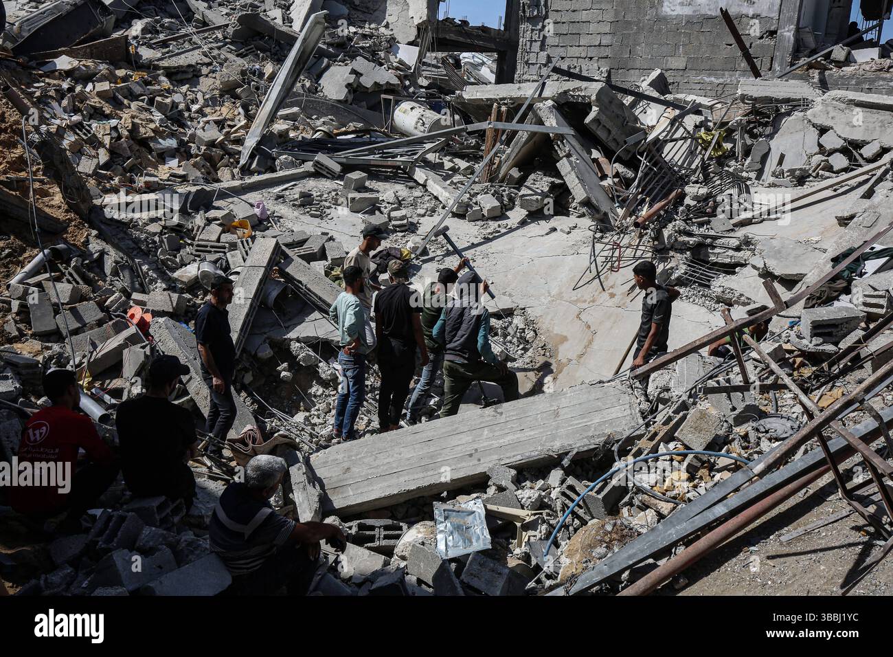 People sift through the rubble of the Zinati family home in Jabalia in ...