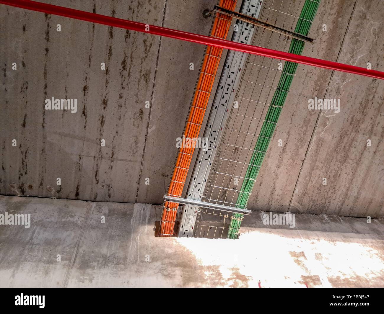 Orange fiber optic and green electrical cables are installed on a ...