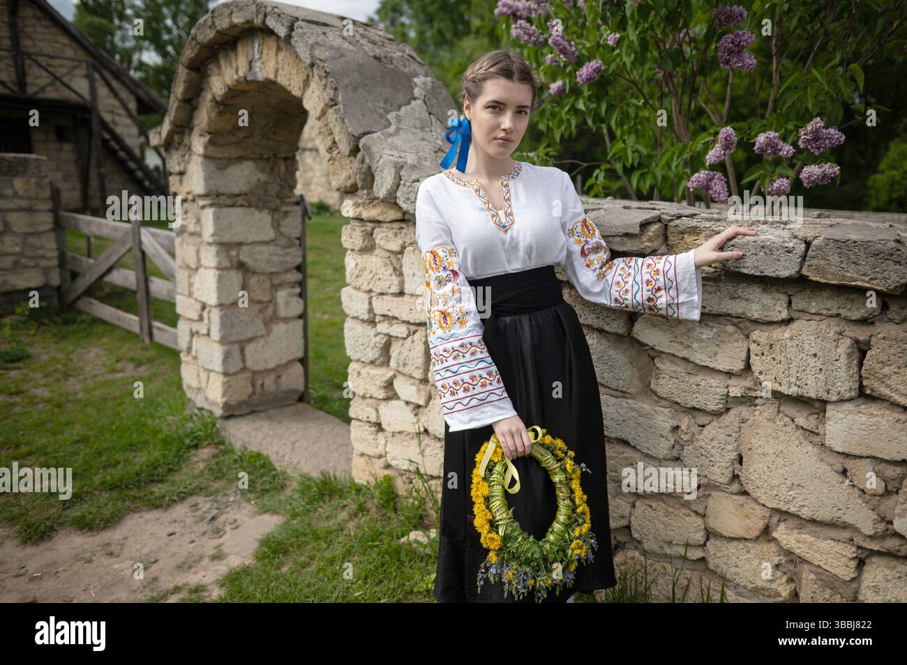 A woman holding a floral crown wears a vyshyvanka (Ukrainian ...