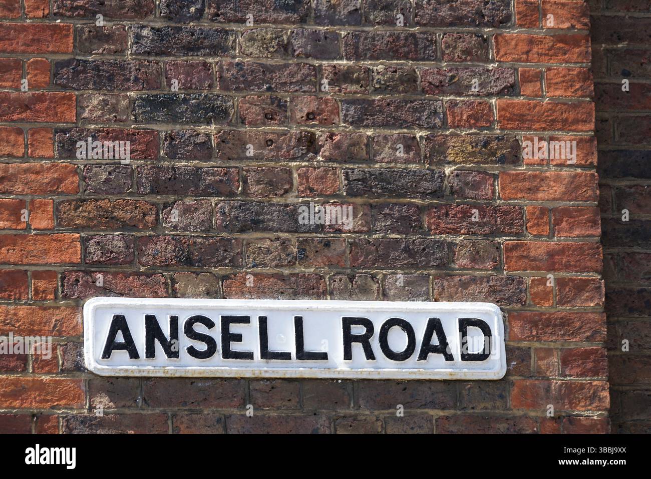 Street Name Sign on a Brick Wall Depicting Location or Navigation ...
