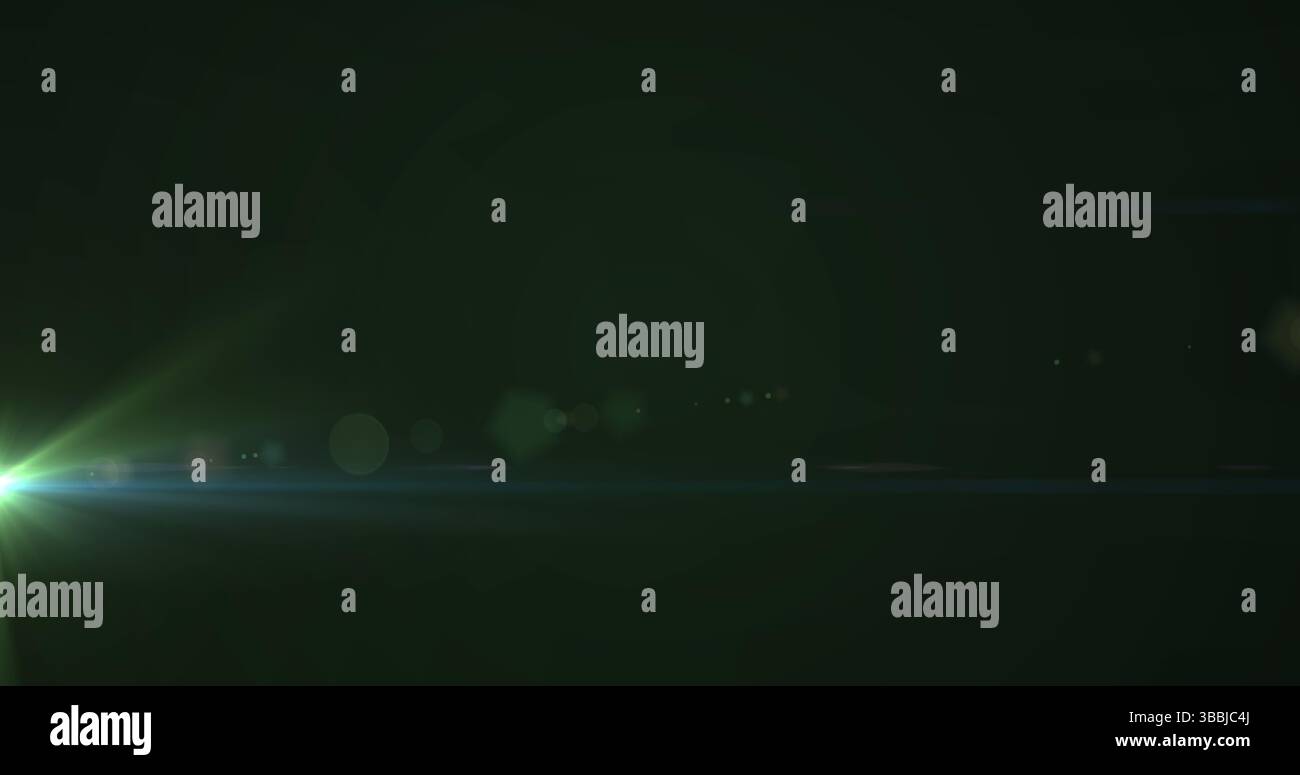 Casting green lens flare streak across black background, with scattered ...