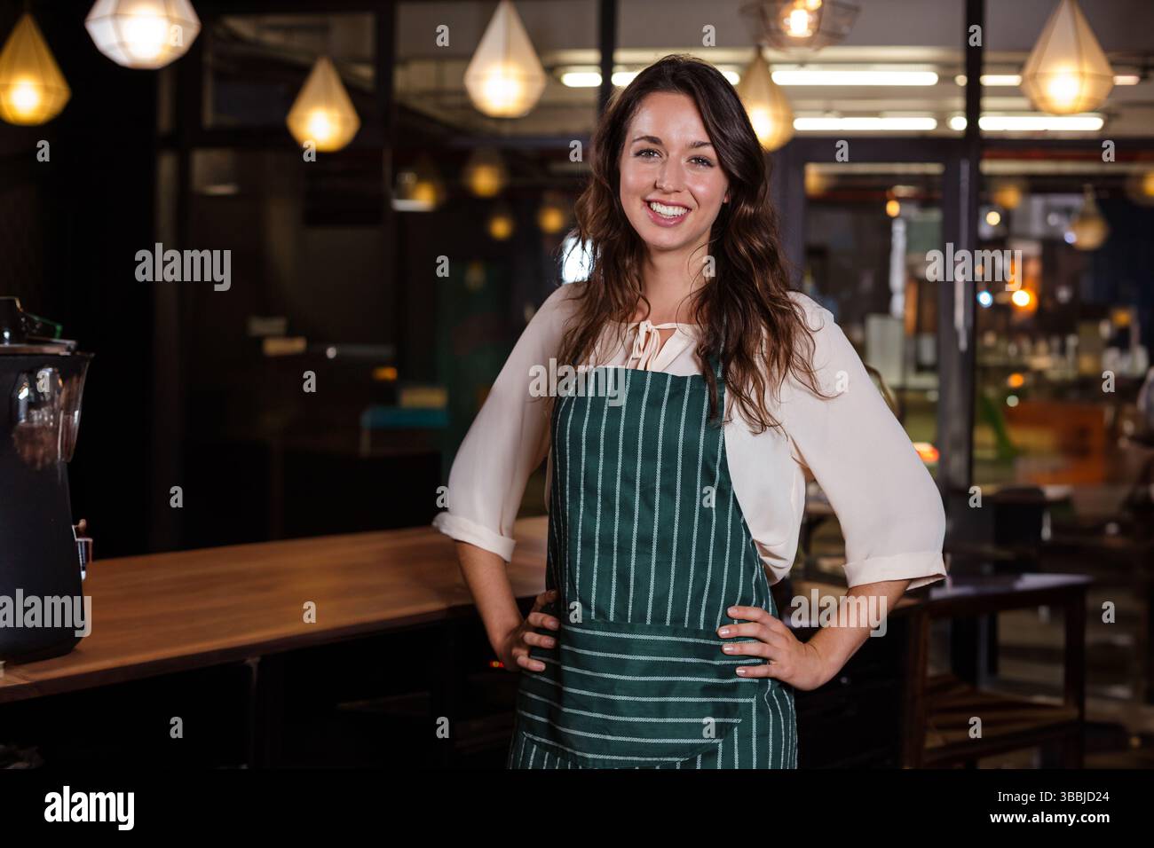 Smiling barista woman serving coffee behind counter at café, with ...