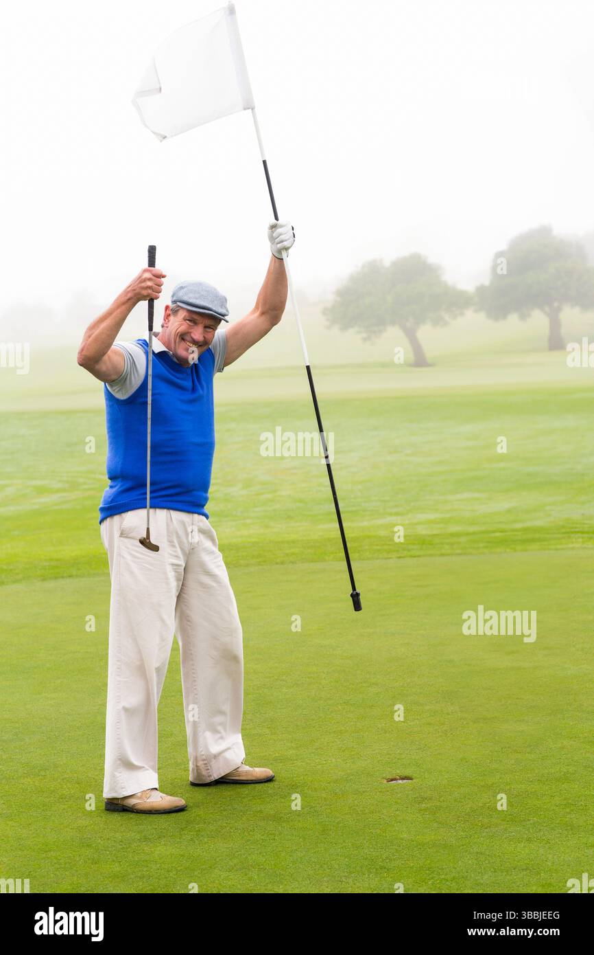 Holding white flagstick, Senior African American man standing on golf ...