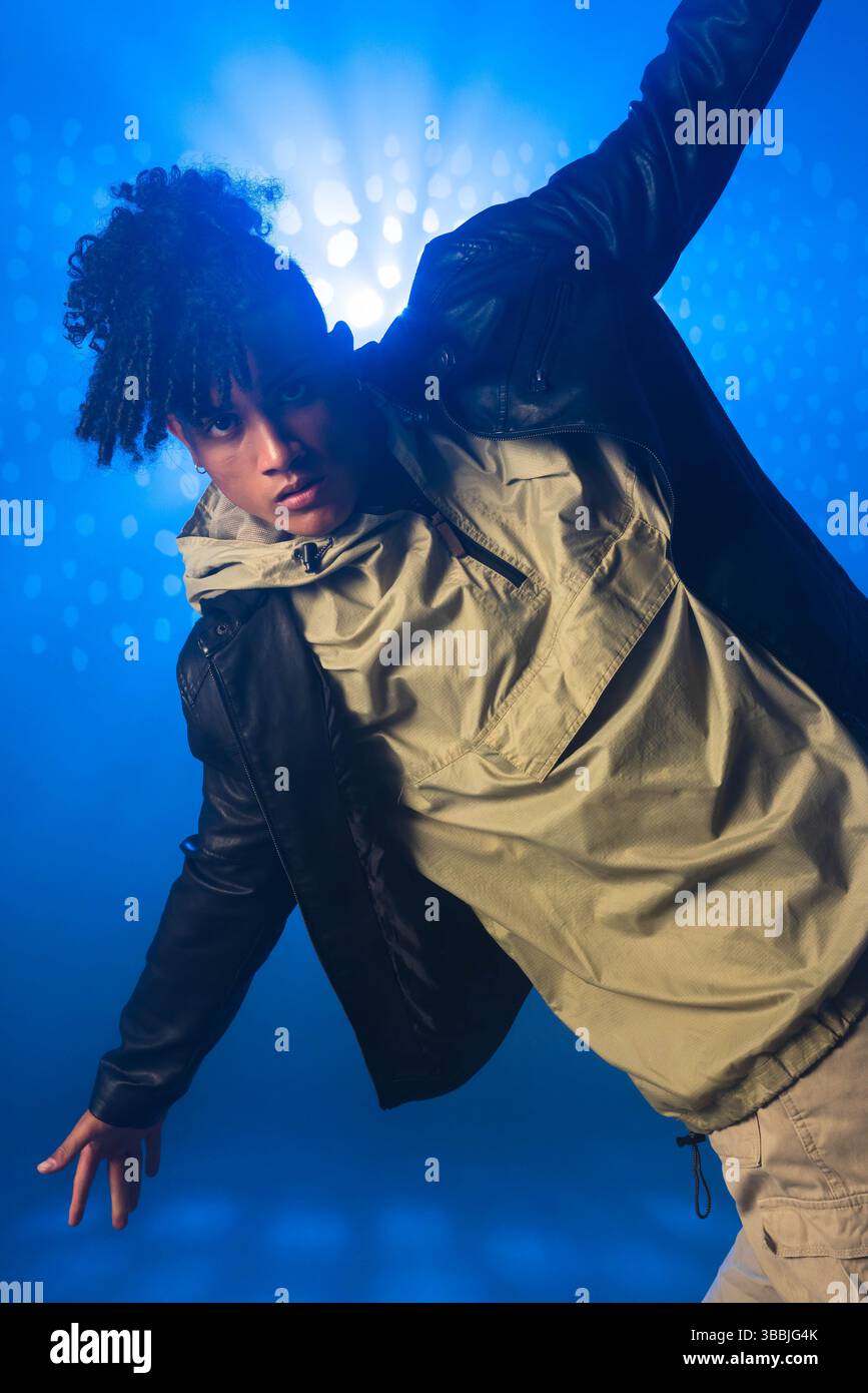 Leaning African American man wearing layered jacket balancing on stage ...