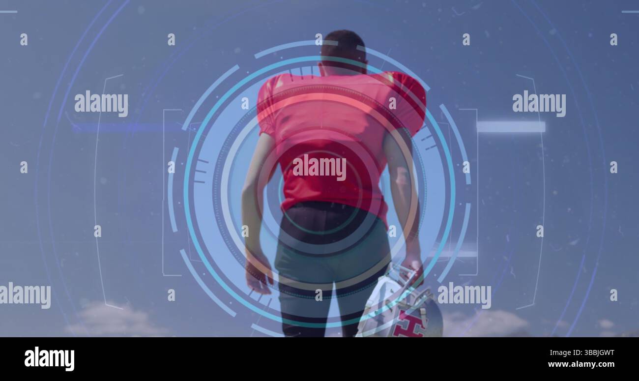 Standing athlete in red football jersey holding helmet by side at open ...