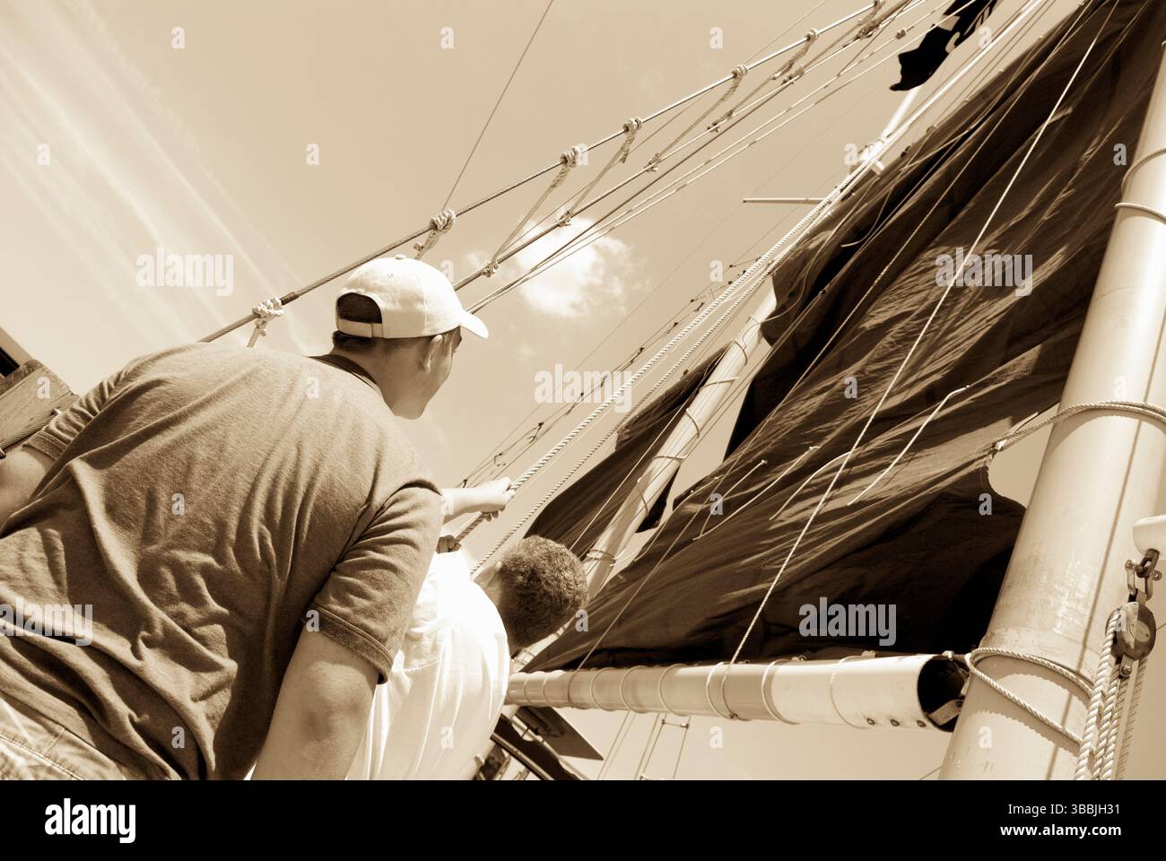 Two boys raising sail aboard the Jolly Rover tall ship docked on the ...