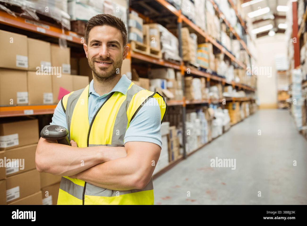 Male warehouse worker scanning barcodes in warehouse aisle, with ...