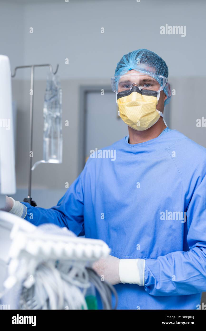 Male healthcare professional adjusting medical monitor in sterile ...
