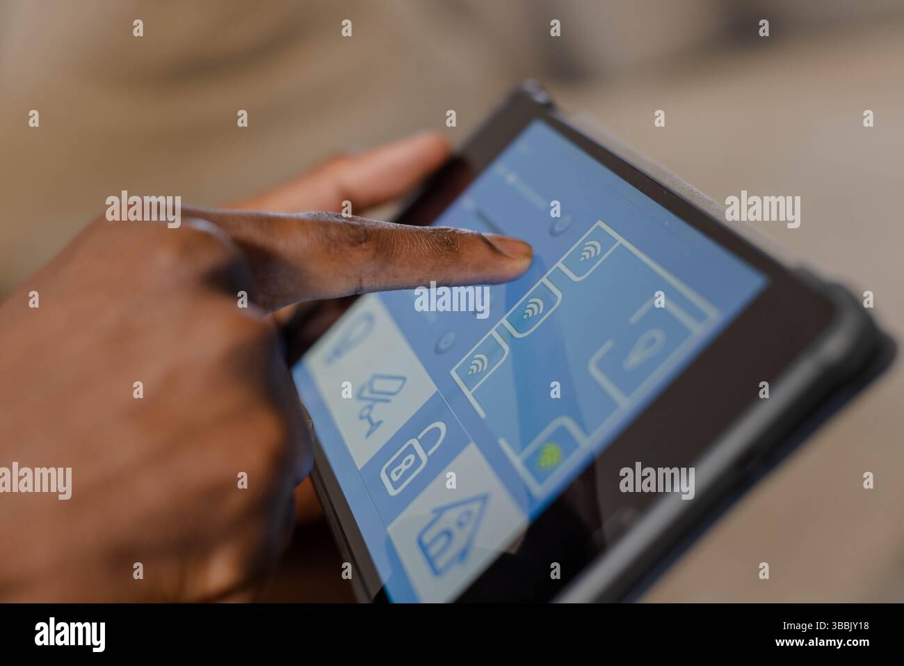 African American man's hand tapping touchscreen tablet in living room ...
