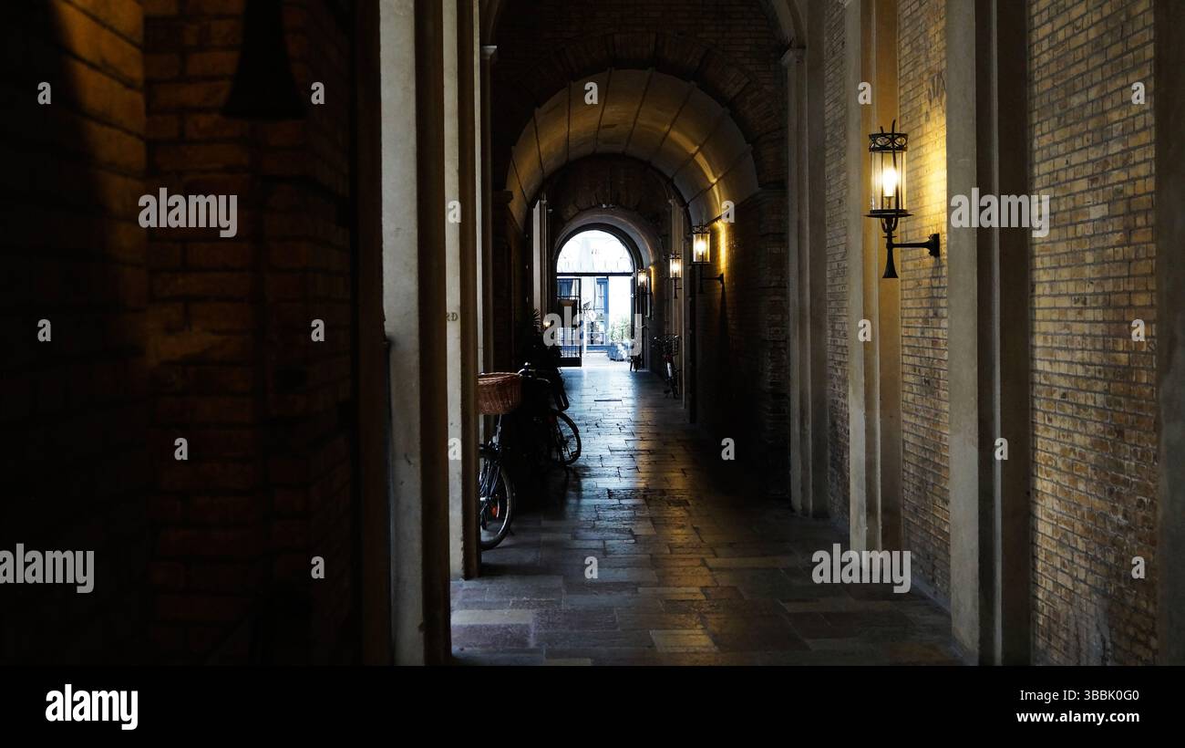 A narrow hallway features bicycles, lanterns, and a classic brick ...