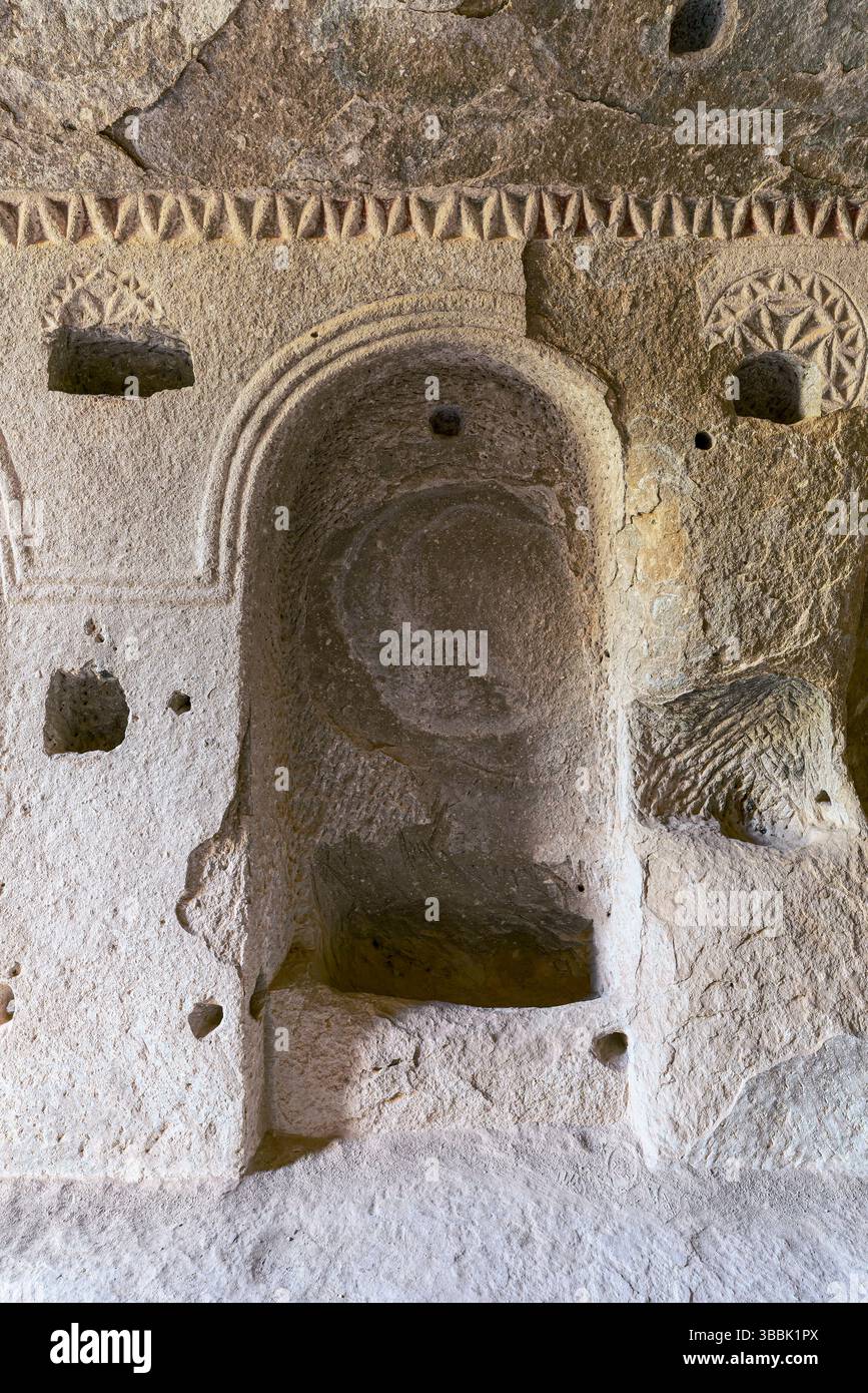A carved apse with cross relief and arched niche decorates the wall of ...
