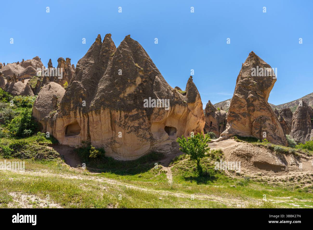 A large rock formation with multiple cave entrances and arched openings ...